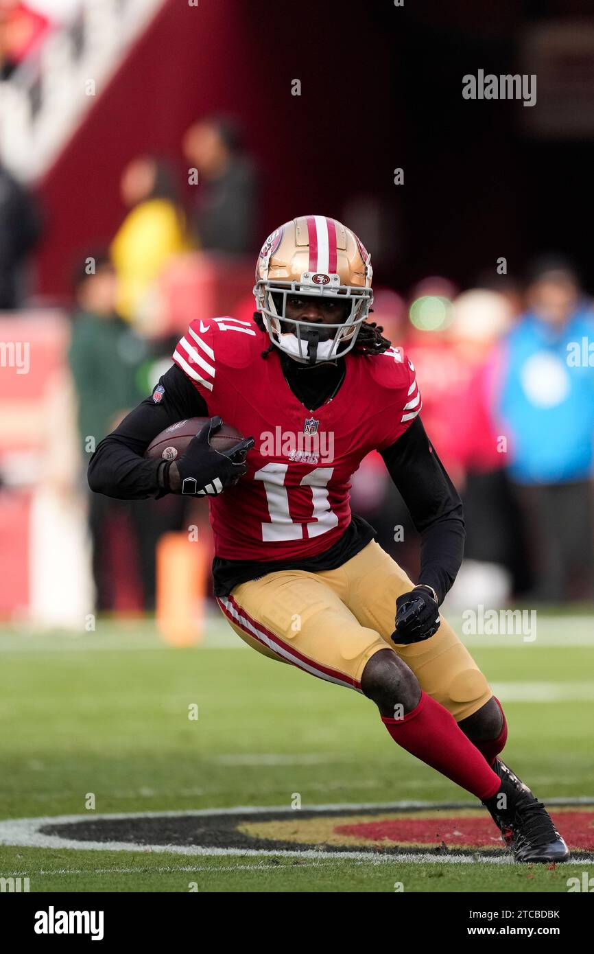 San Francisco 49ers wide receiver Brandon Aiyuk, left, runs with the ...