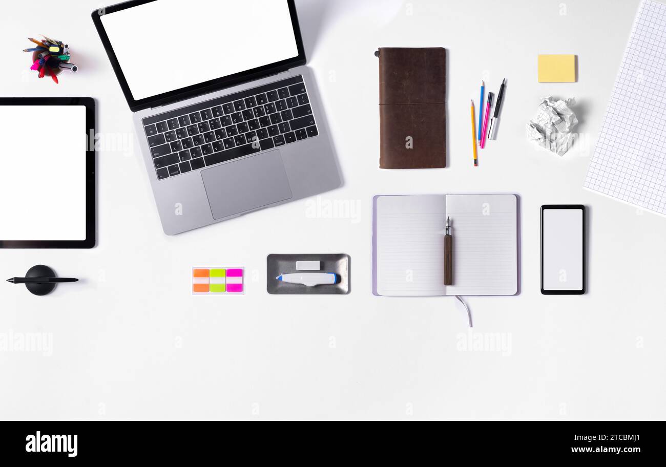 Laptops and stationery for work on the desk are arranged (blank screen ...
