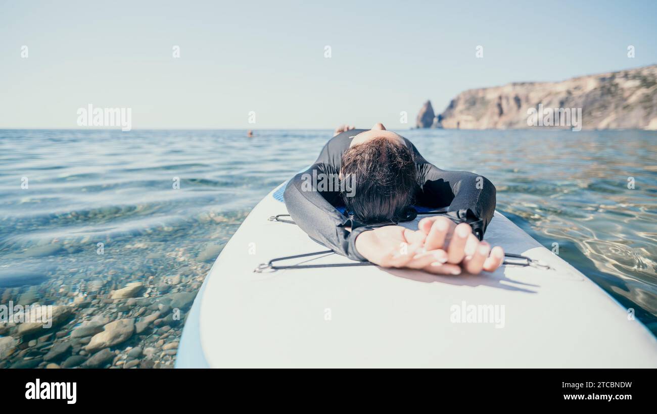 Woman sup yoga. Happy sporty woman practising yoga pilates on paddle ...
