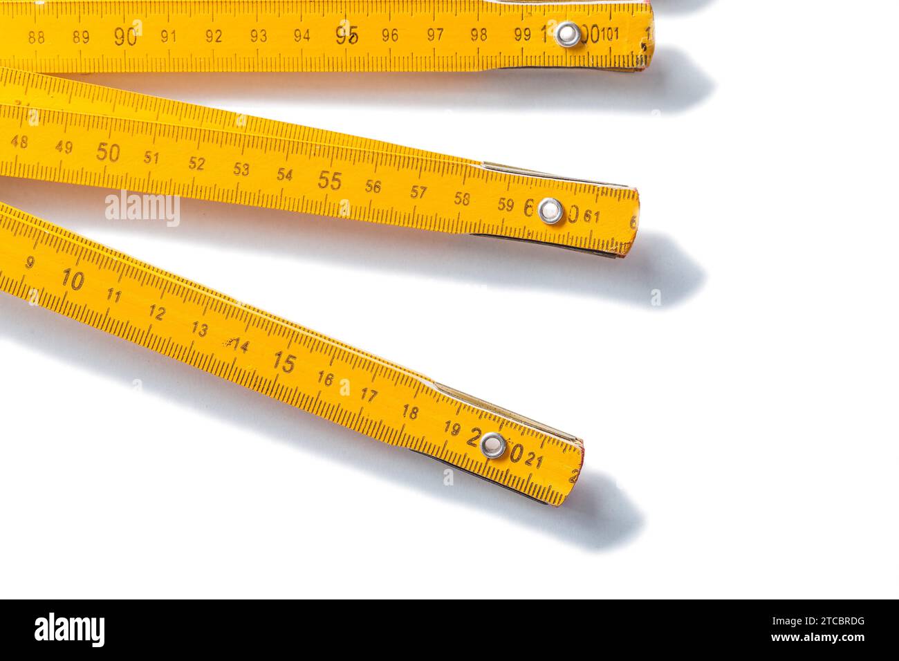 Very close-up view of yellow wooden metre against white background ...