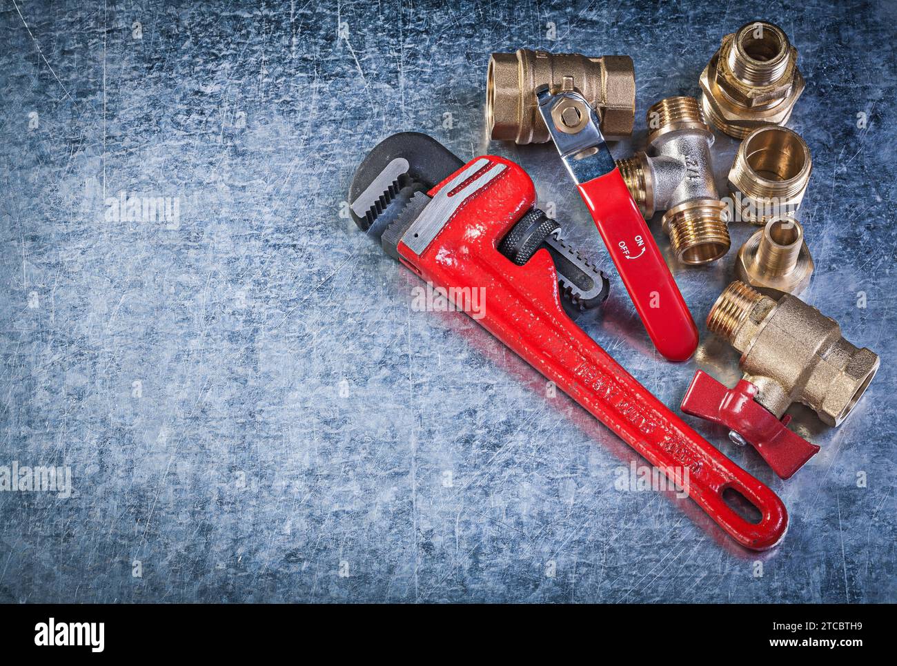 Brass pipe connector monkey spanner on metallic background plumbing ...