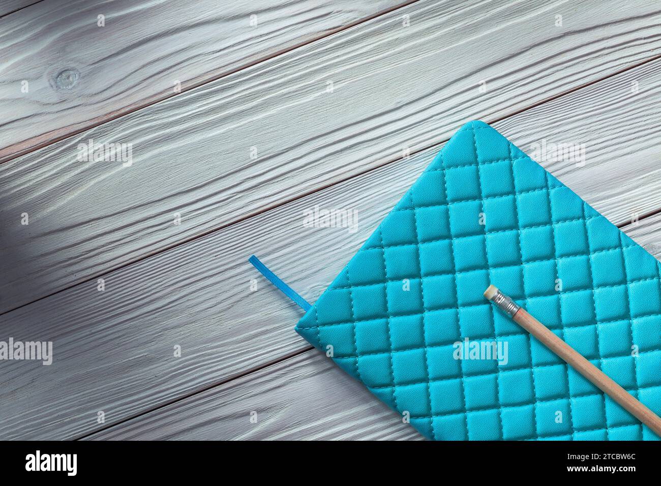 Blue notepad with classic pencil on white vintage wooden board up close ...