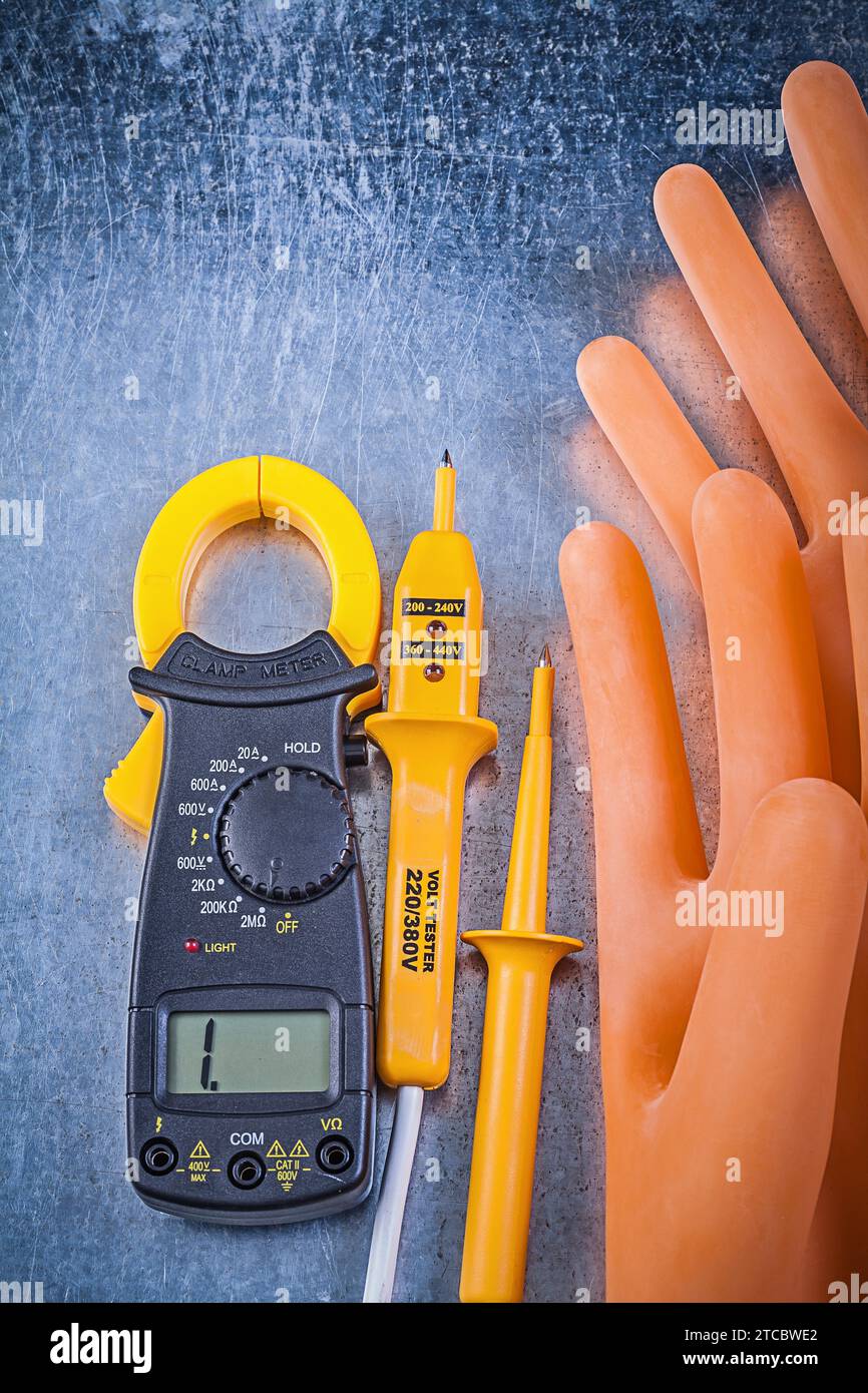 Digital ammeter electrical tester electrician rubber gloves on metallic ...