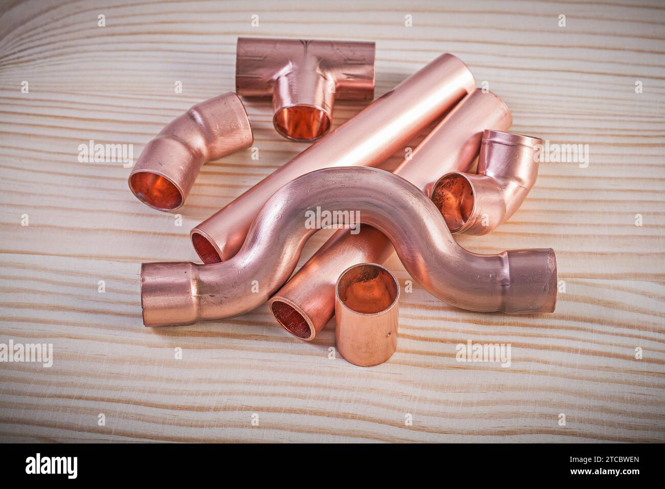 Copper pipe fittings on wooden panel Sanitary concept Stock Photo - Alamy