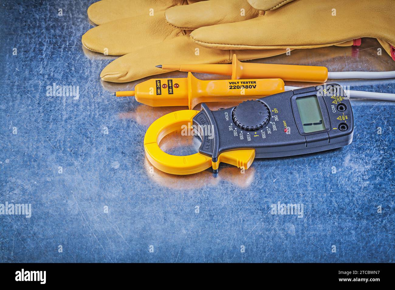 Digital clamp meter Electrical tester Safety gloves on metallic ...