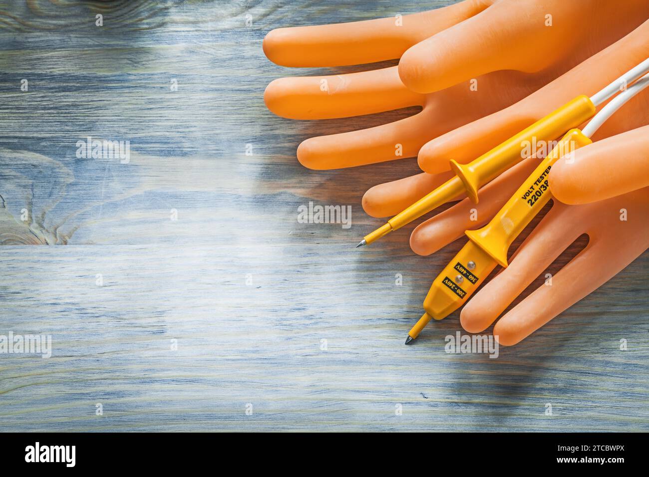 Electrical tester dielectric gloves on wooden board Electricity concept ...