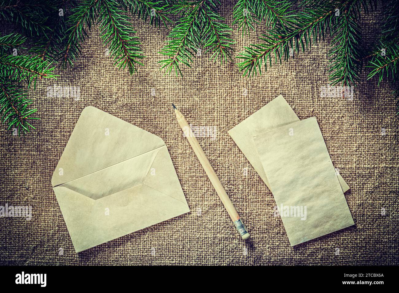 Fir branch envelope paper pencil on bagging background Stock Photo - Alamy