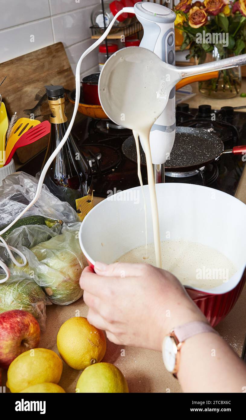 Homemade Kitchen Hostess Pouring Pancake Mix from Ladle into Leaking ...