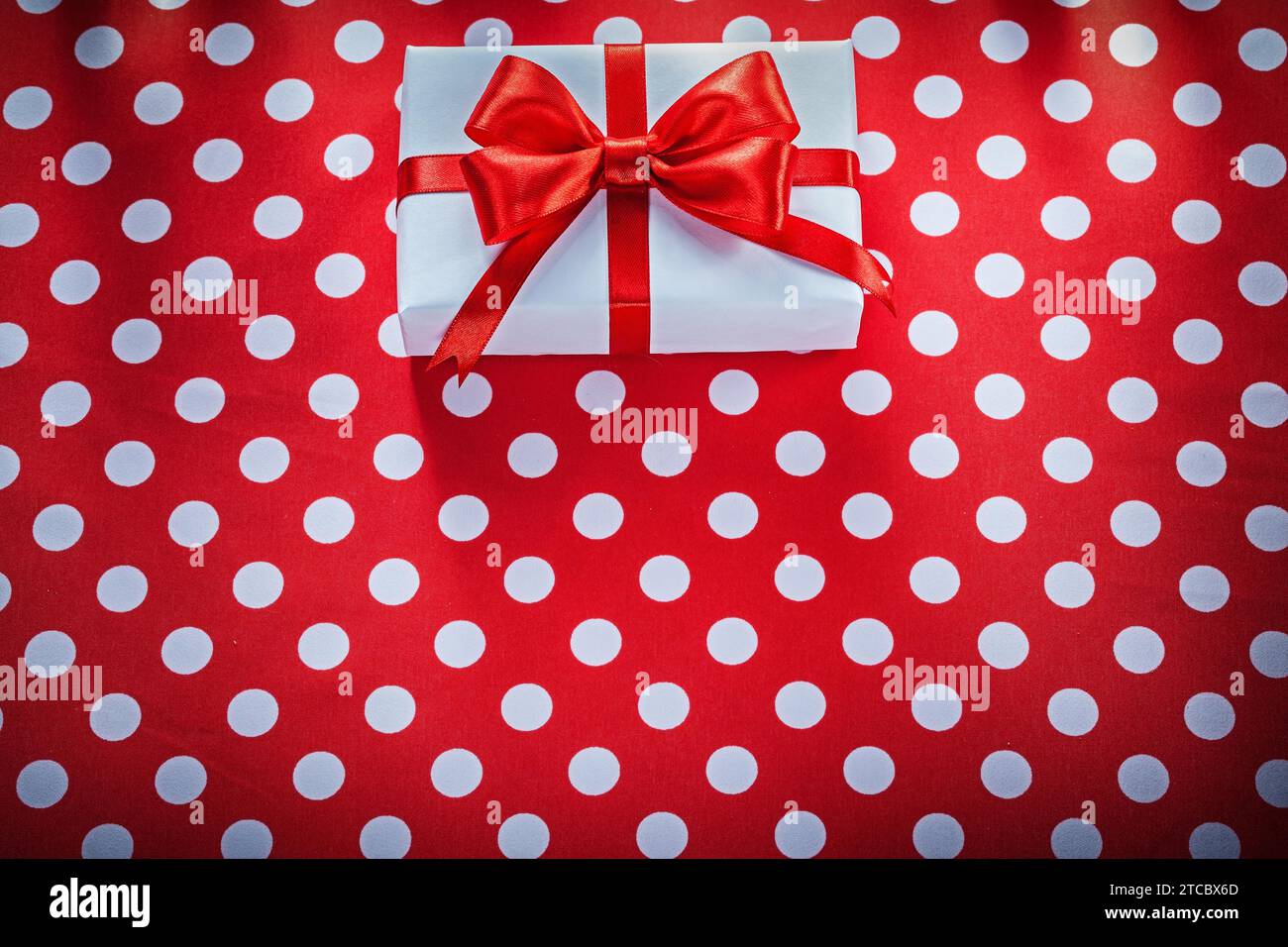 Gift box on dotted red fabric Celebration concept Stock Photo - Alamy
