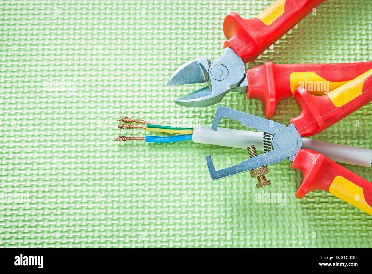 Insulation strippers pliers electric wires on green background ...