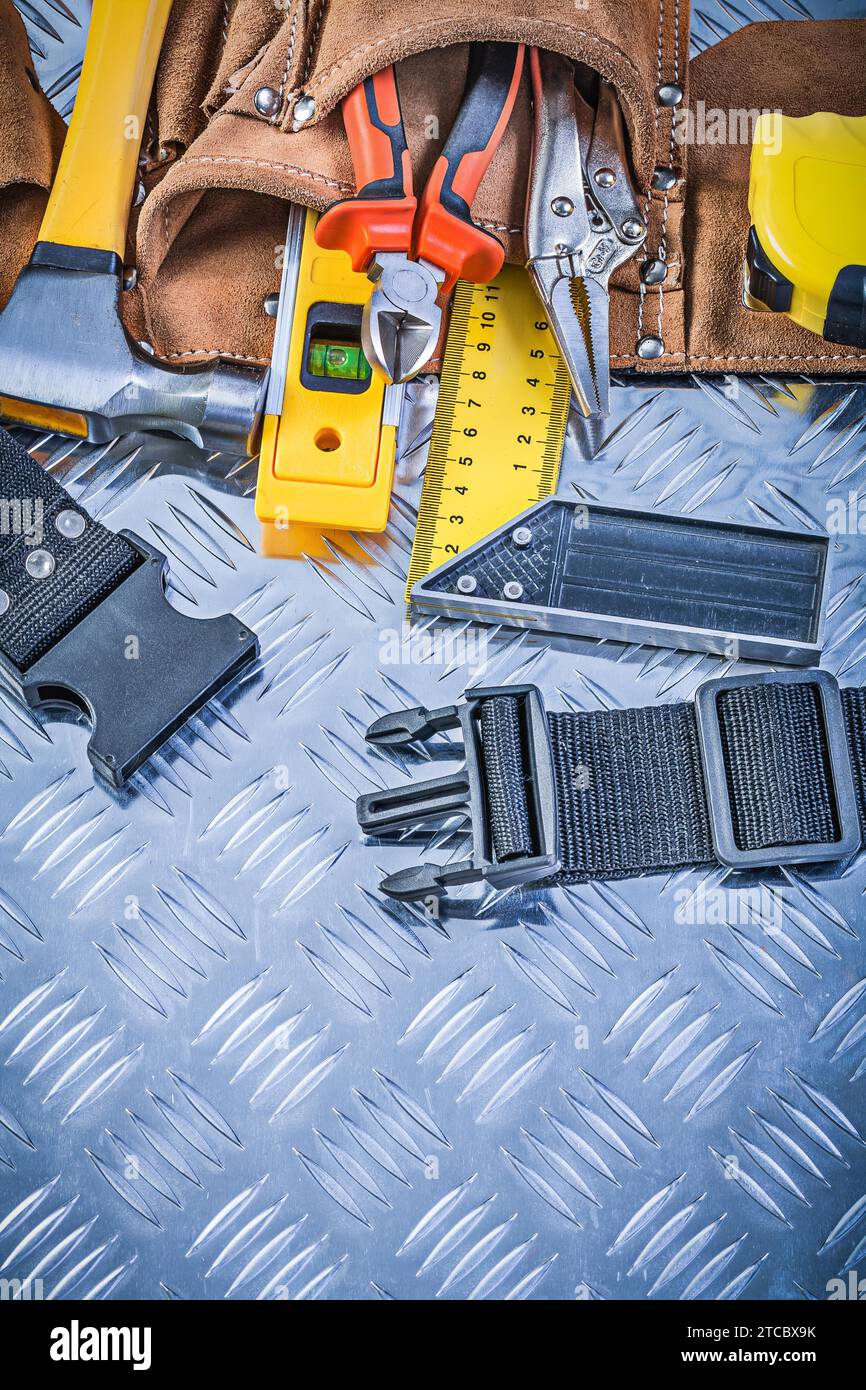 Leather construction belt with construction tools on grooved sheet ...