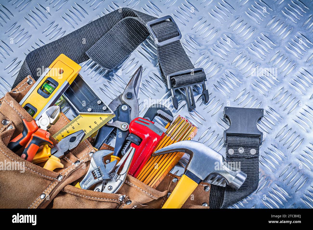 Leather tool belt with construction objects on grooved metal sheet ...