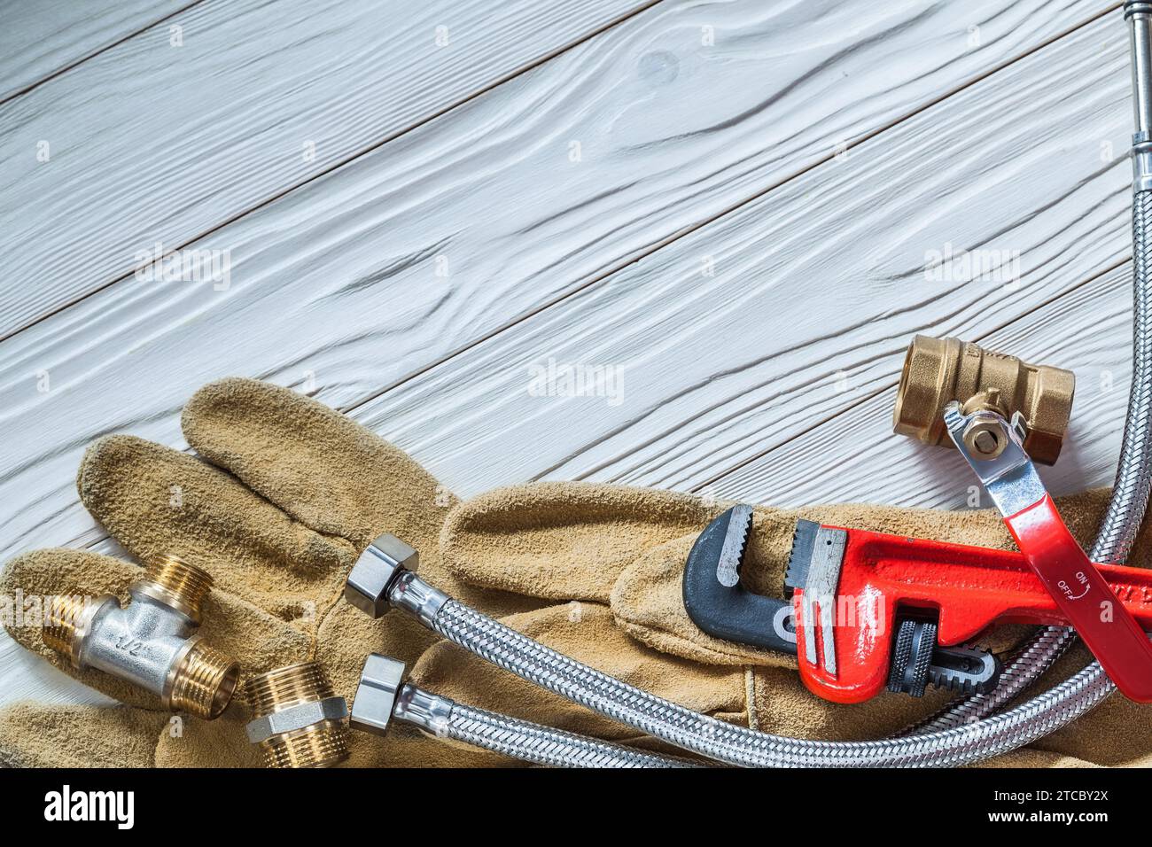 Plumbing tools Adjustable spanner Jigs and fixtures Gloves on wooden ...