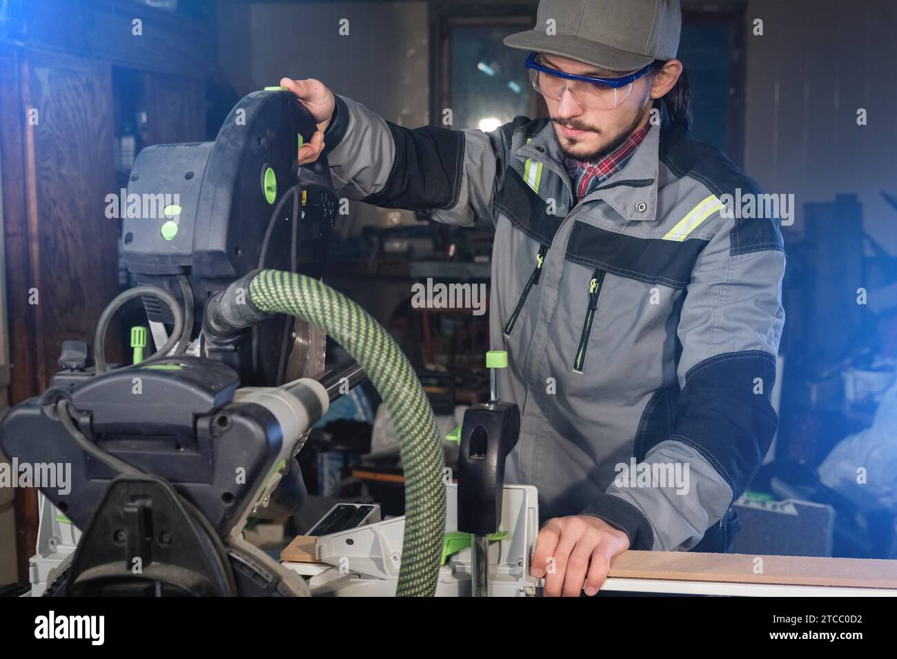 Young brunette man wearing a cap in a gray jacket by profession a ...