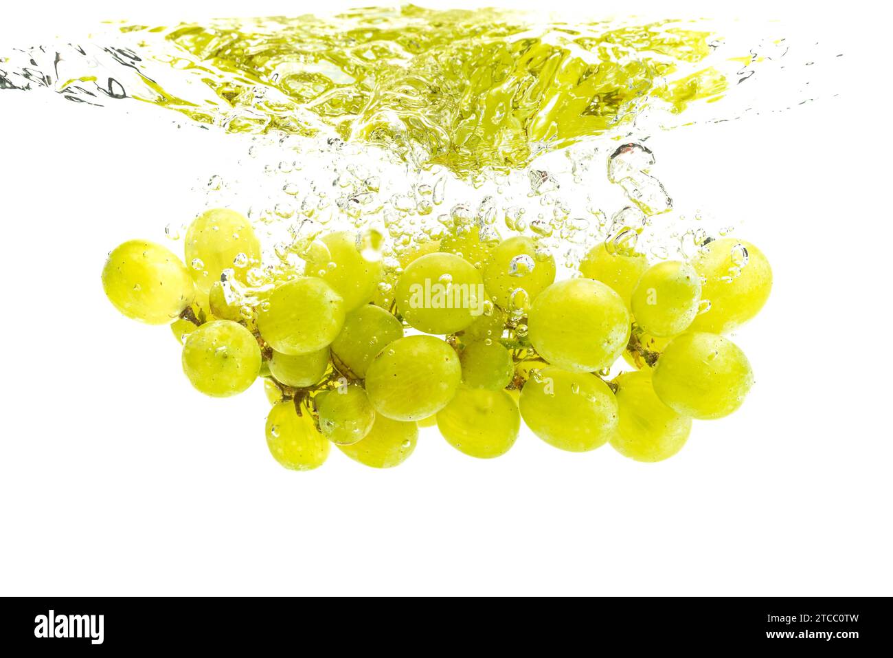 Bunch of green grapes sinking into crystal clear water with air bubbles ...