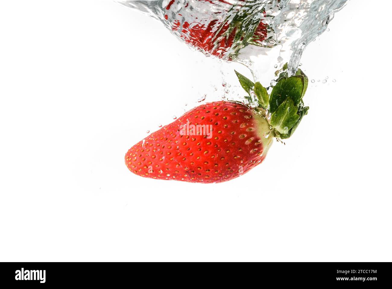Strawberry splashing into crystal water Stock Photo - Alamy