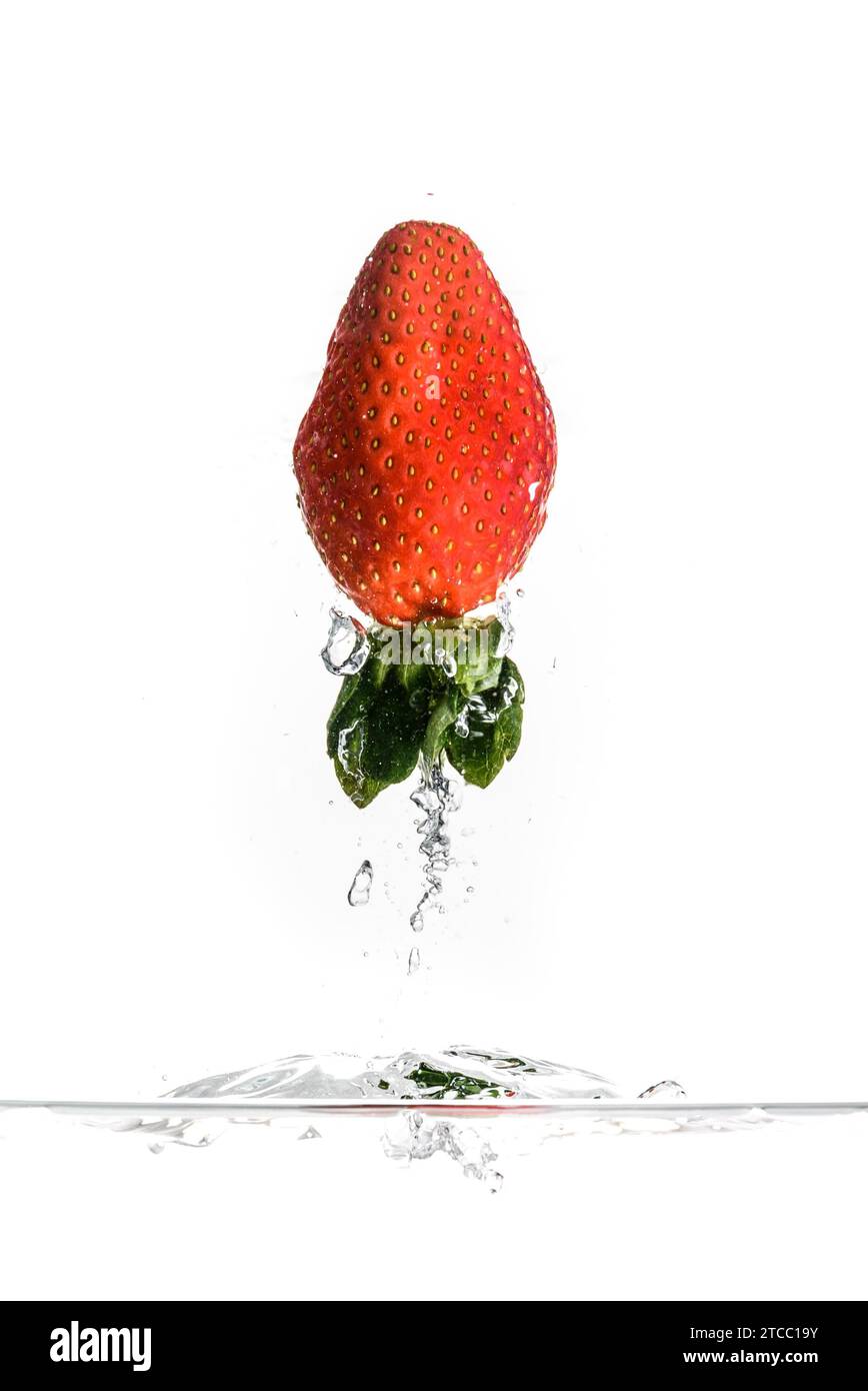 Strawberry splashing into crystal water isolated white background Stock ...