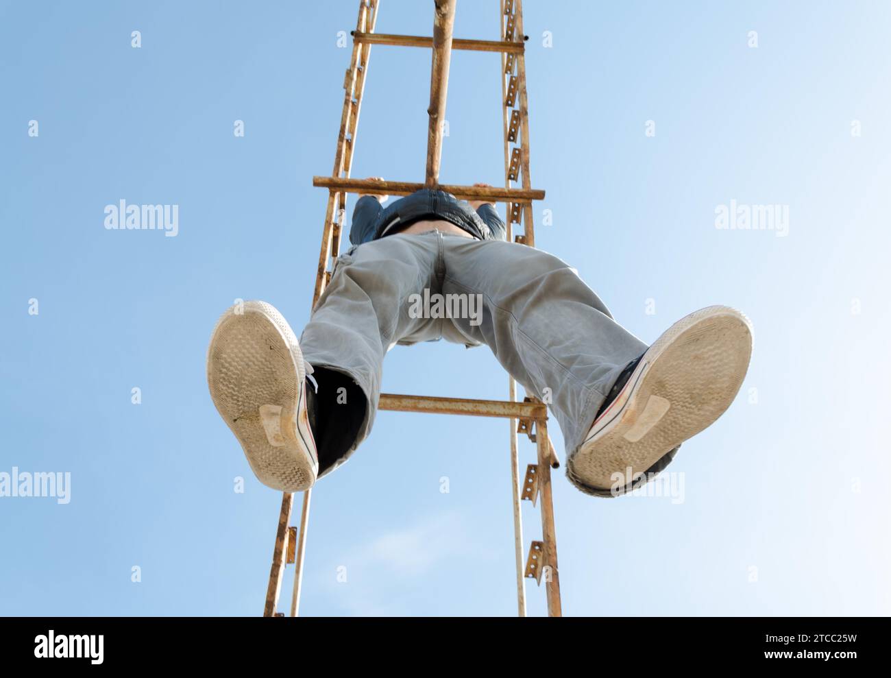 Man in keds hanging holding his hands for a rusty old structure Stock ...