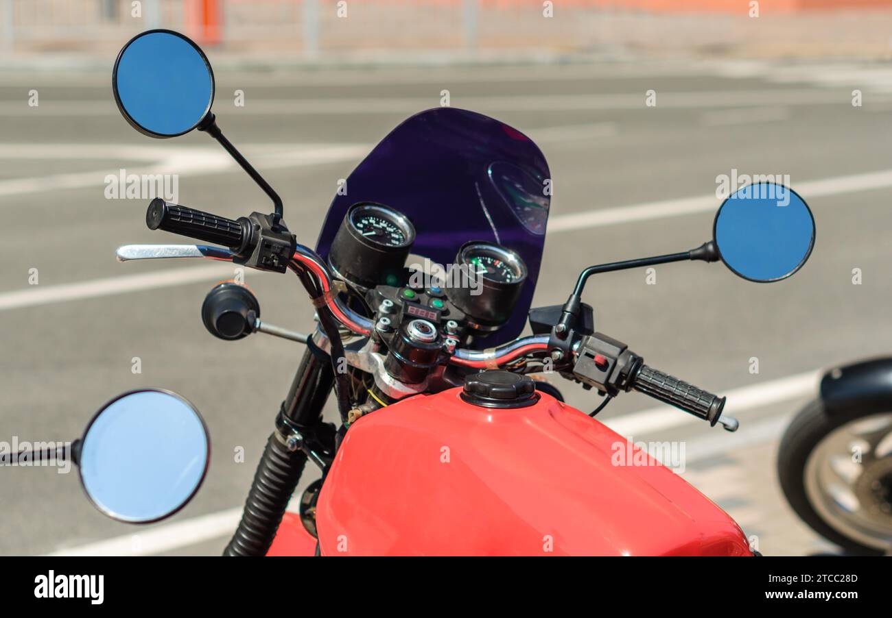 Steering wheel of a red motorcycle cafe racer closeup Stock Photo - Alamy