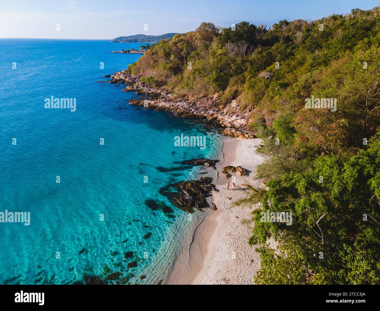 aerial drone view from above at a couple of men and woman on the beach ...