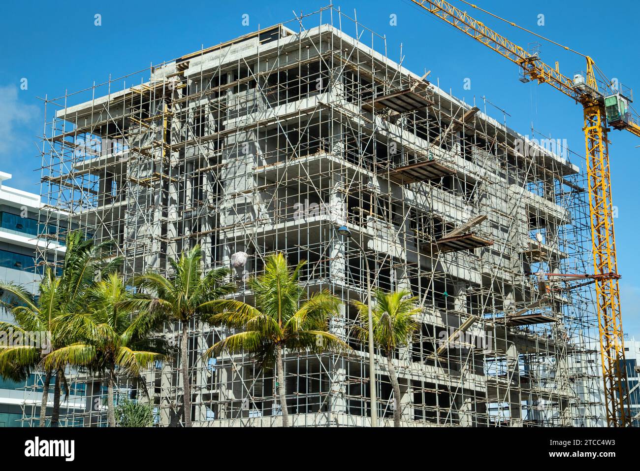 High building under construction with scaffolding and building crane in Port Louis and on ...