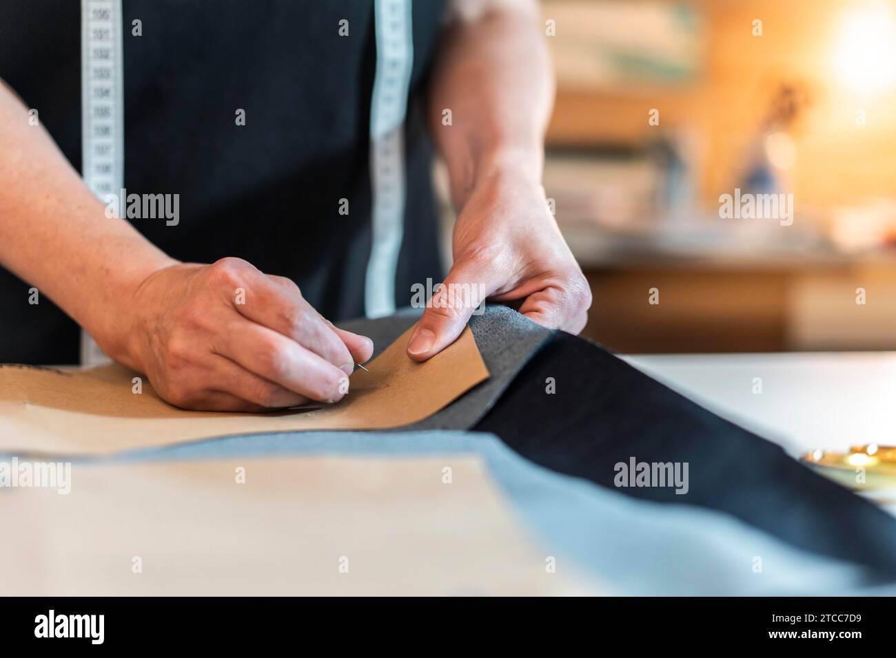Fashion designer putting pins into pattern and fabric Stock Photo - Alamy