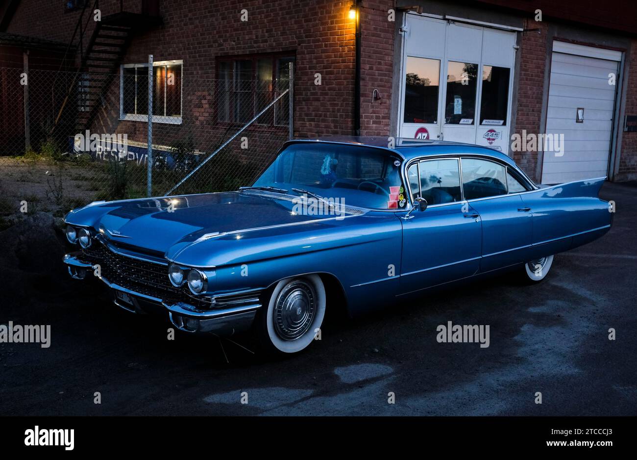 American classic car, blue Cadillac in front of red brick building ...