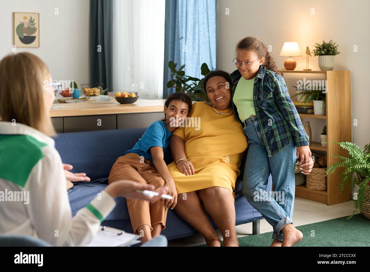 Happy adoptive family talking to social worker during their meeting at ...