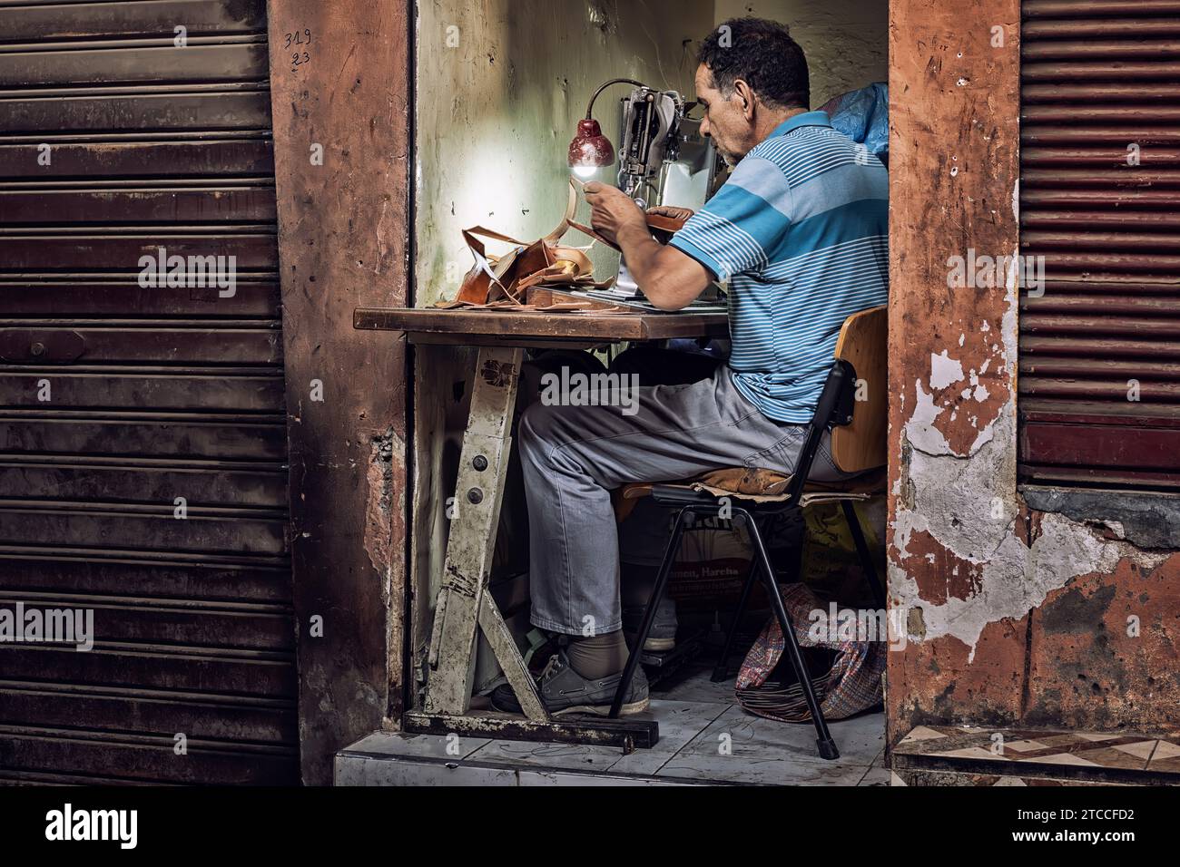 Marrakesh, Morocco: leather artisan working inside a small workshop at ...