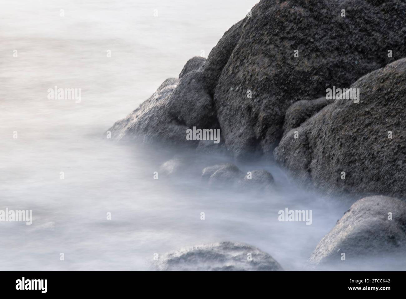 slow exposure shots of the sea waves along the rocky beach Stock Photo ...
