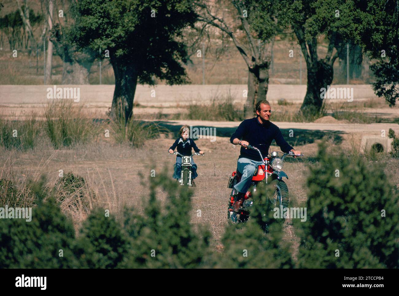 Madrid, 1976. Prince Felipe riding a motorcycle with his father, King ...
