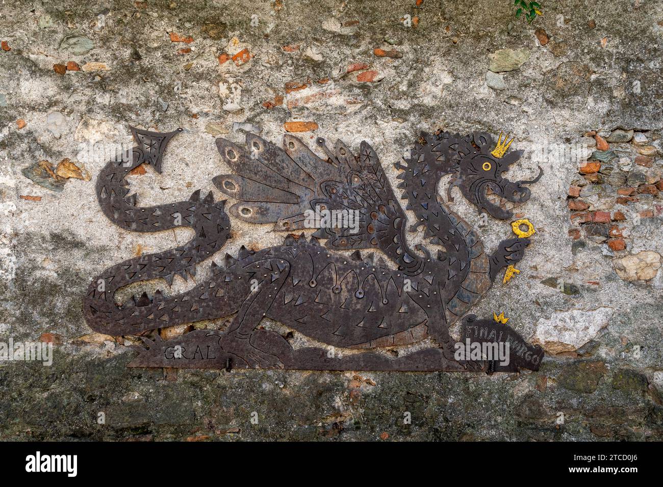 Wrought iron dragon by Gral on an old brick wall in the medieval ...