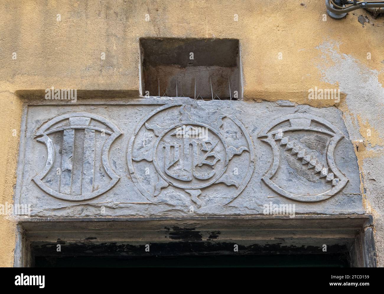 Stone bas-relief with the religious symbol JHS between two coat of arms ...