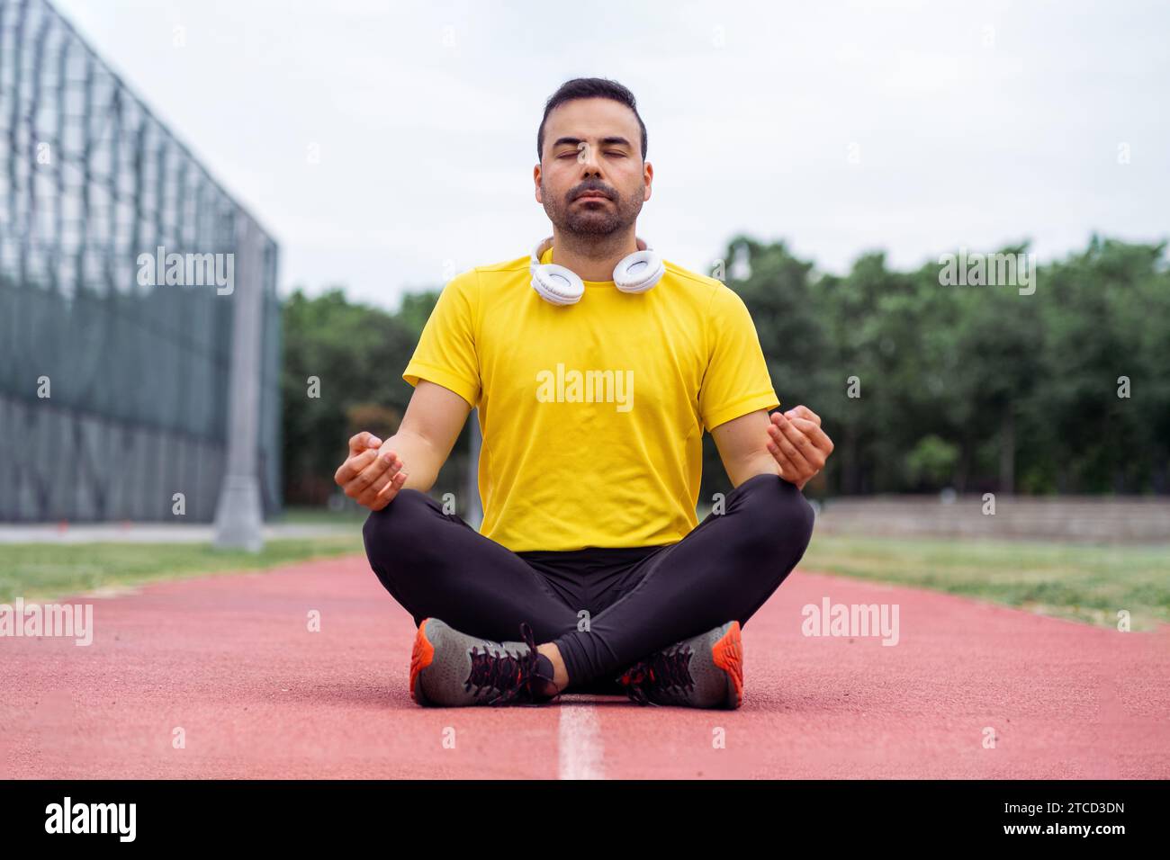 Peaceful sportsman, practices mindfulness meditating in lotus pose on a ...