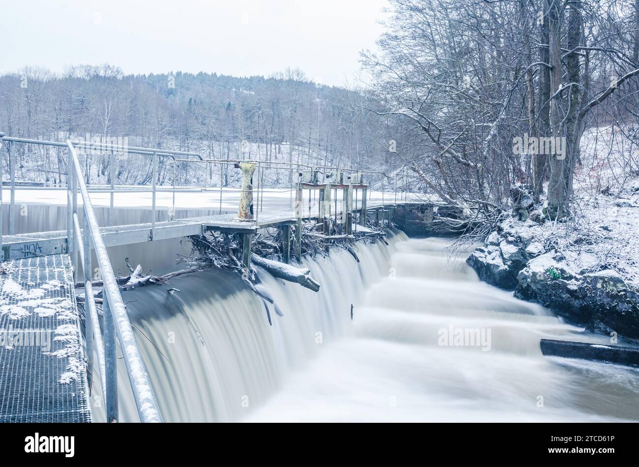 Winter waterfall at a dam surrounded by snowy trees Stock Photo - Alamy