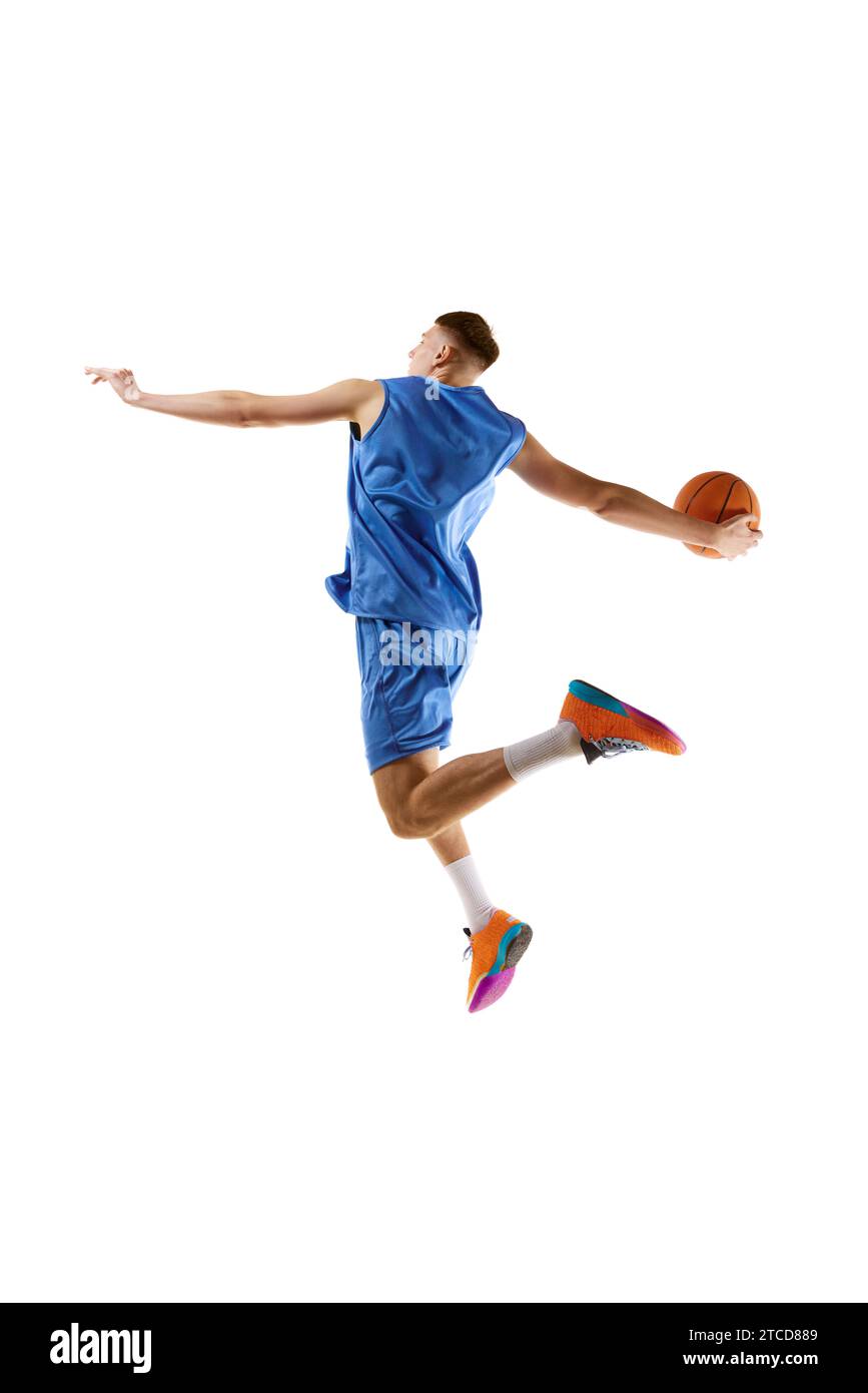 Slum dunk. Full-length image of young guy, basketball player in motion ...