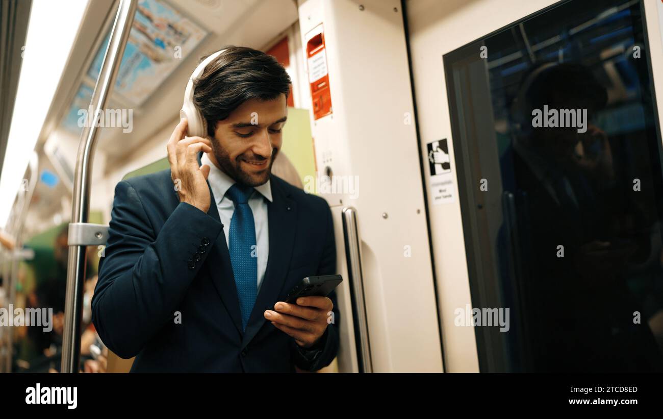 Smart executive manager wear headphone and listen music while standing ...
