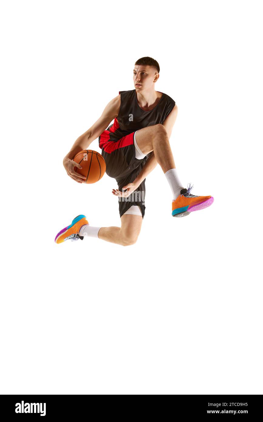 Young competitive guy, basketball player in uniform playing, training ...