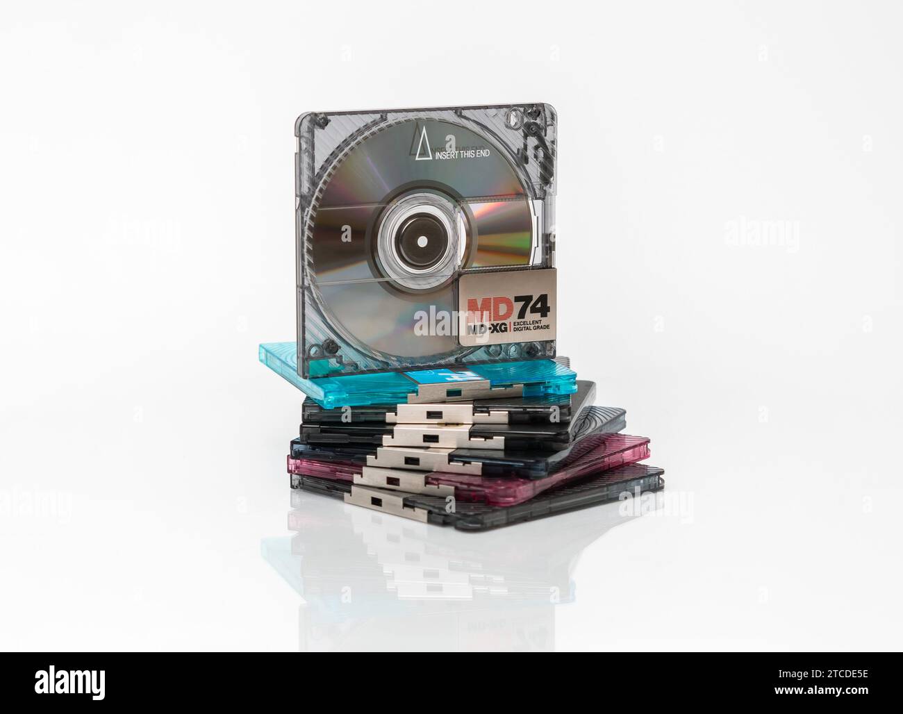 A minidisc stands vertically on a stack of other minidiscs on a white ...