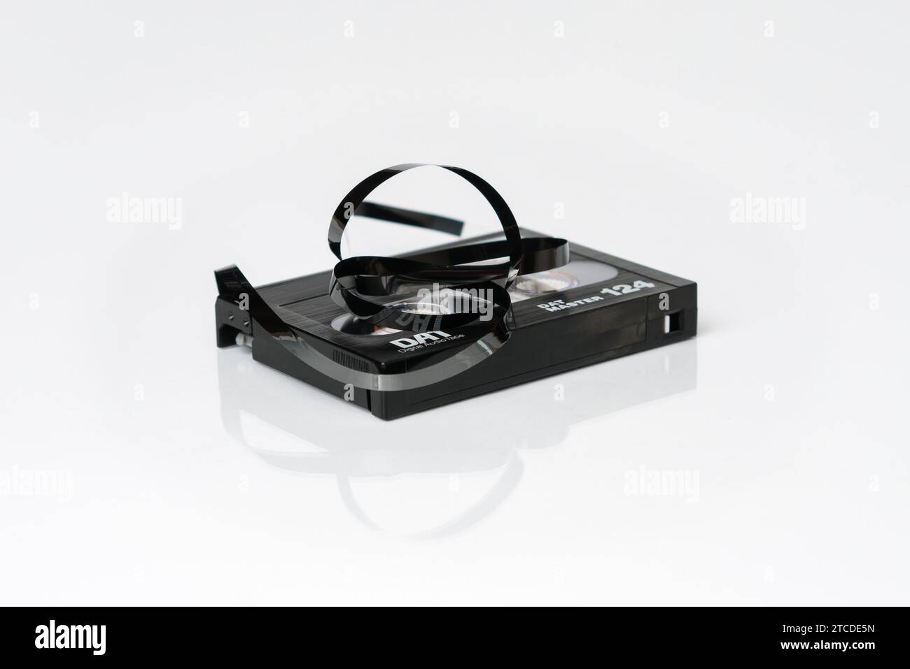 DAT (Digital Audio Tape) cassette with twisted tape isolated on white ...