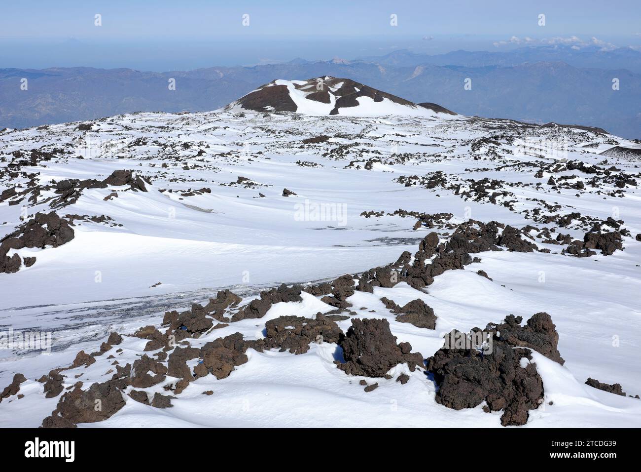 snowy lava field, volcanic rocks and inactive crater on Mount Etna ...