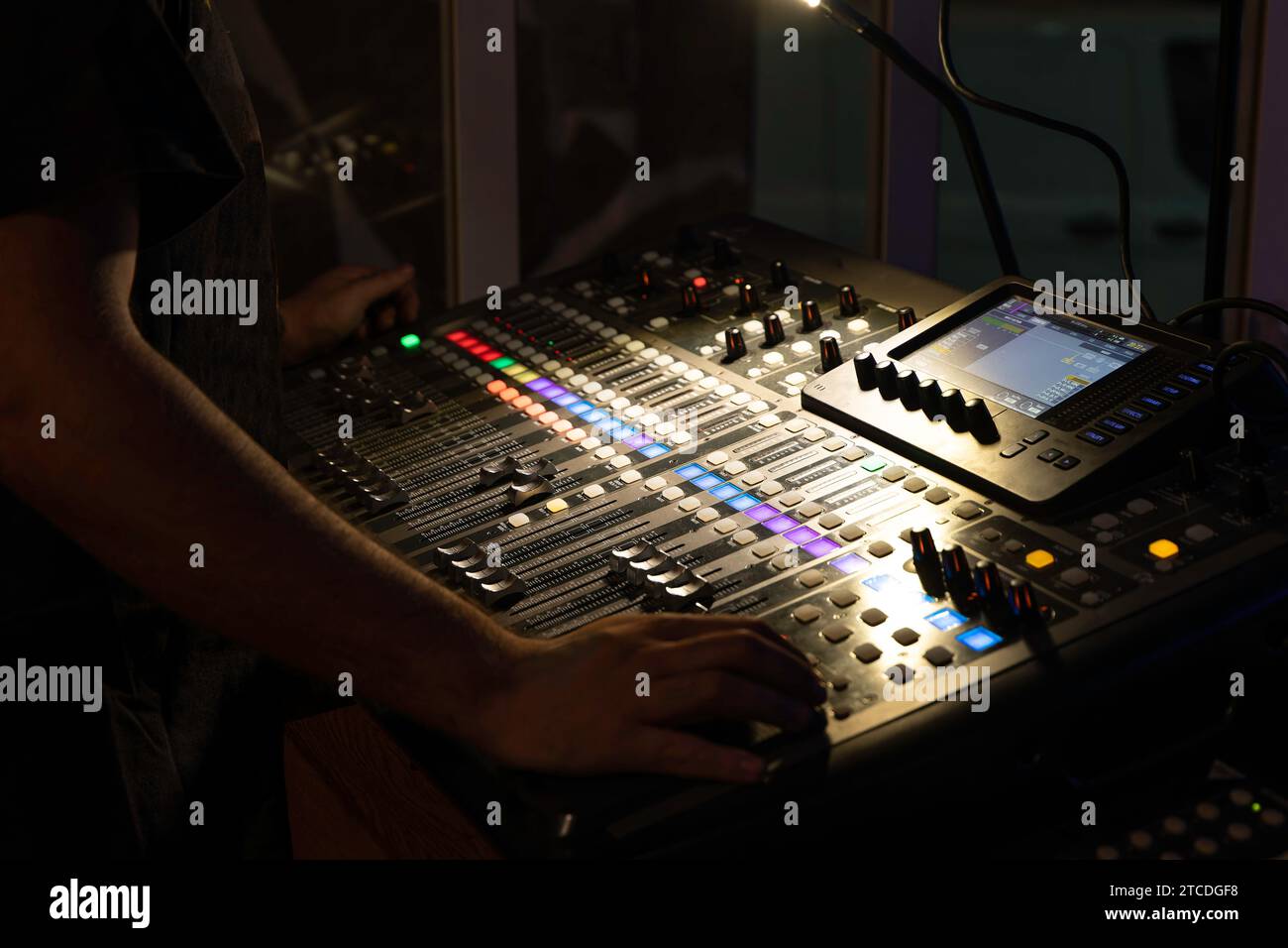 unrecognizable sound technician operating a multitrack mixing console ...