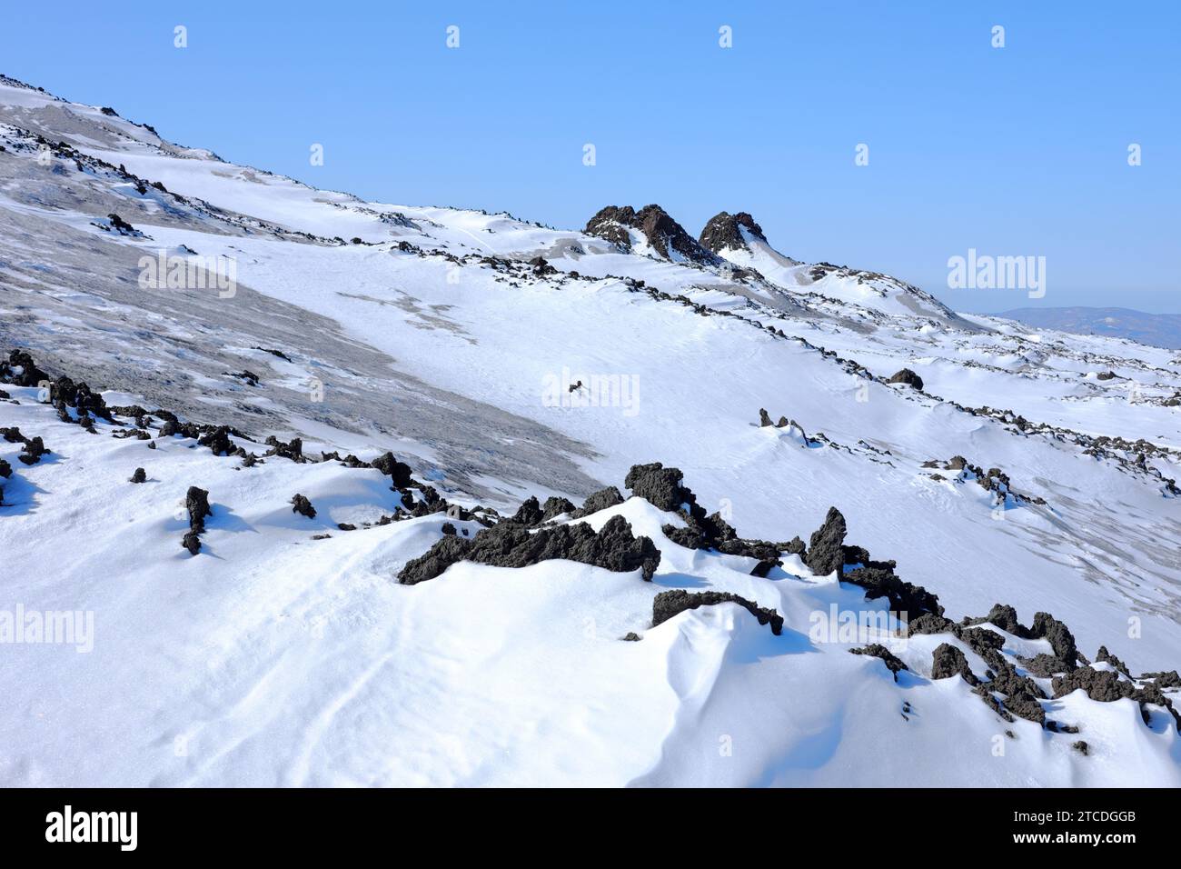 approaching on volcanic rocks snow covered to "I Due Pizzi" or "Frati ...