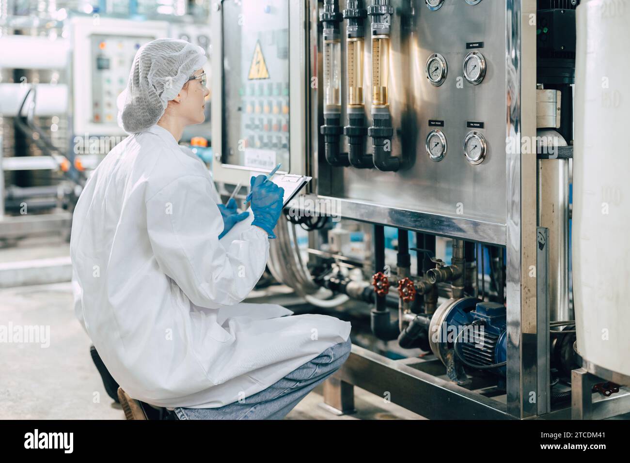 Worker in drinking water plant clean hygiene drink factory quality ...
