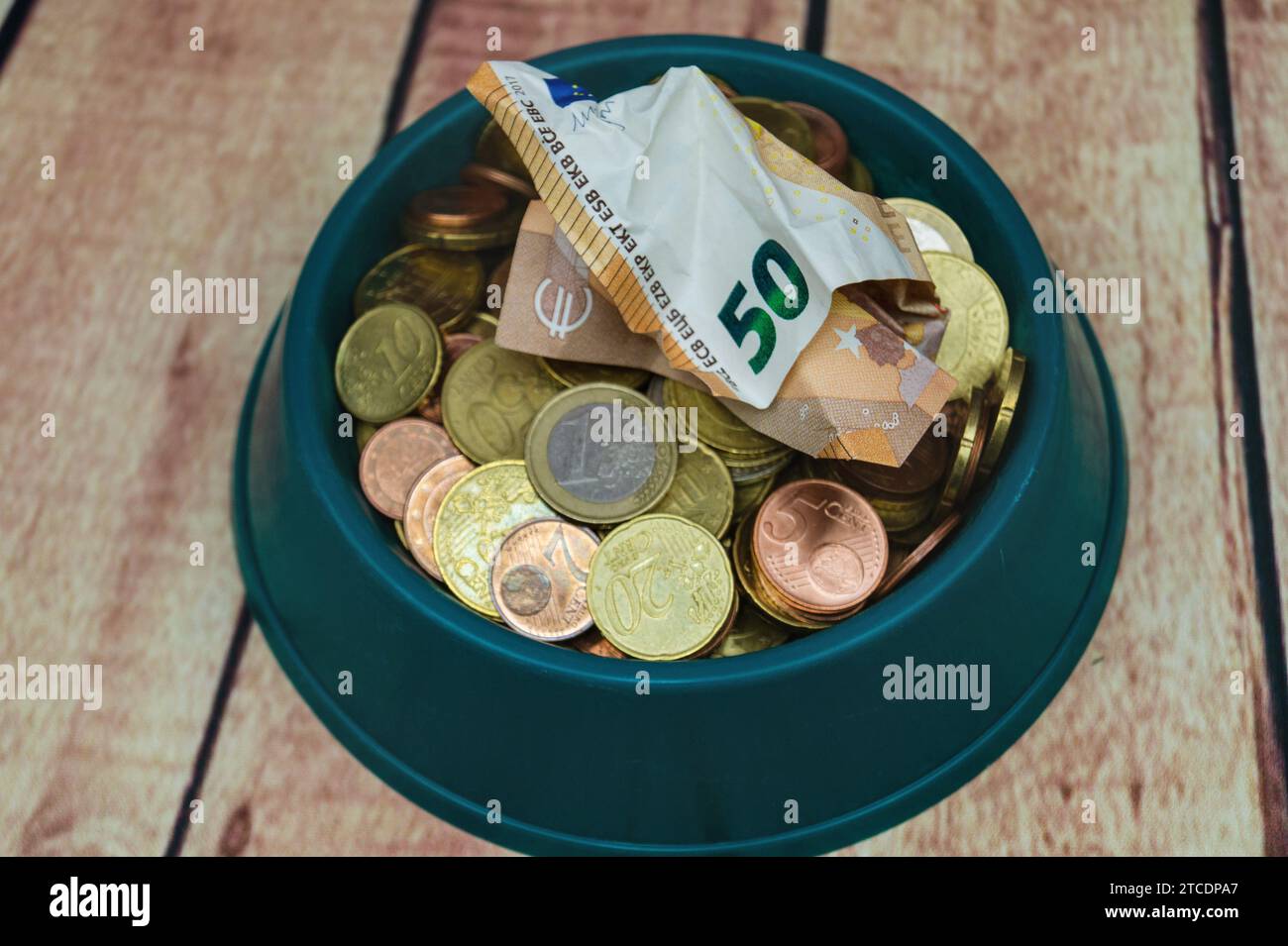 coins and banknotes in the feeding bowl, symbol for feeding costs Stock ...
