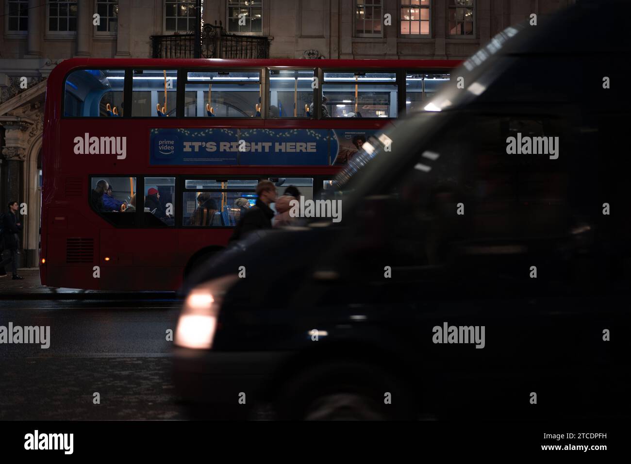 A classic red bus navigates through the winter streets of London ...
