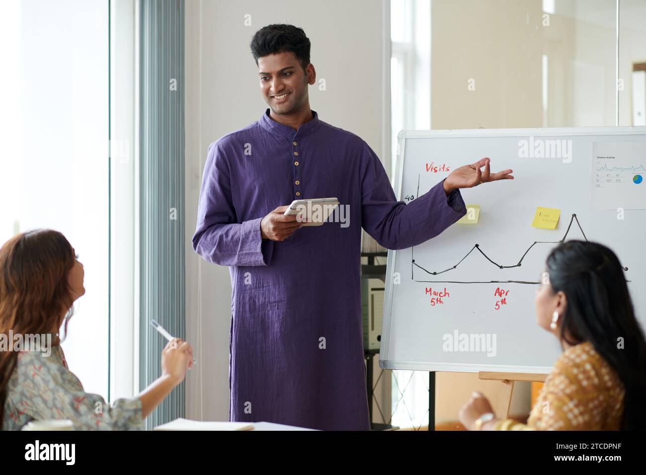 Positive Indian businessman answering questions of colleagues and ...