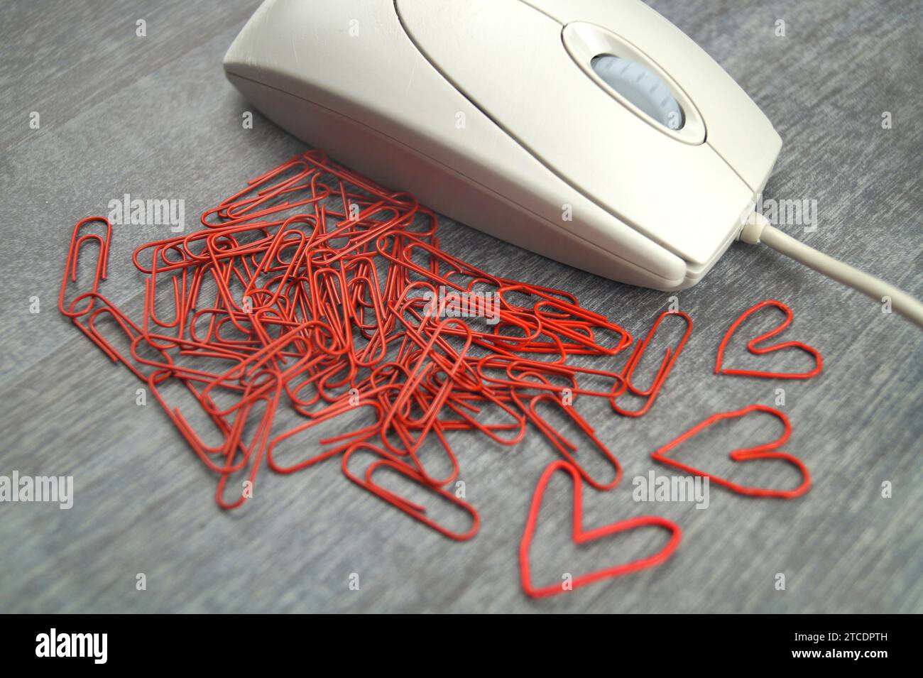 computer mouse with red paper-clips, three of them heart-shaped, love ...