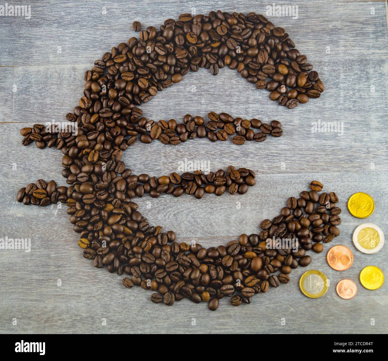 Euro sign, formed with roasted coffee beans, with Euro coins, coffee ...
