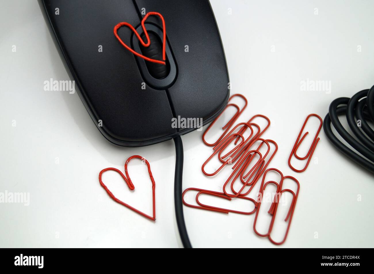 computer mouse with red paper-clips, two of them heart-shaped, love in ...